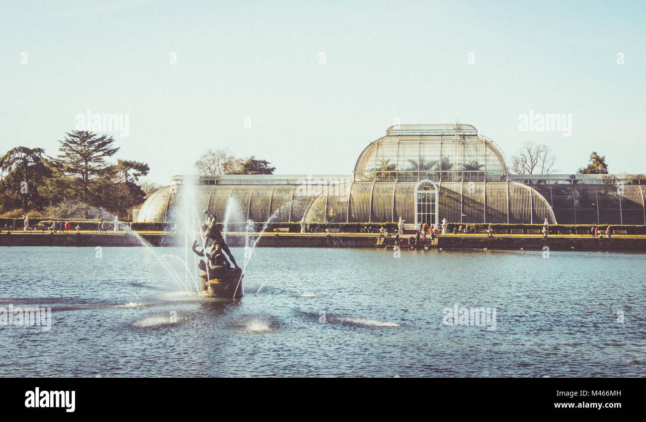 A view of the iconic Palm House at Kew Gardens from across the lake ...