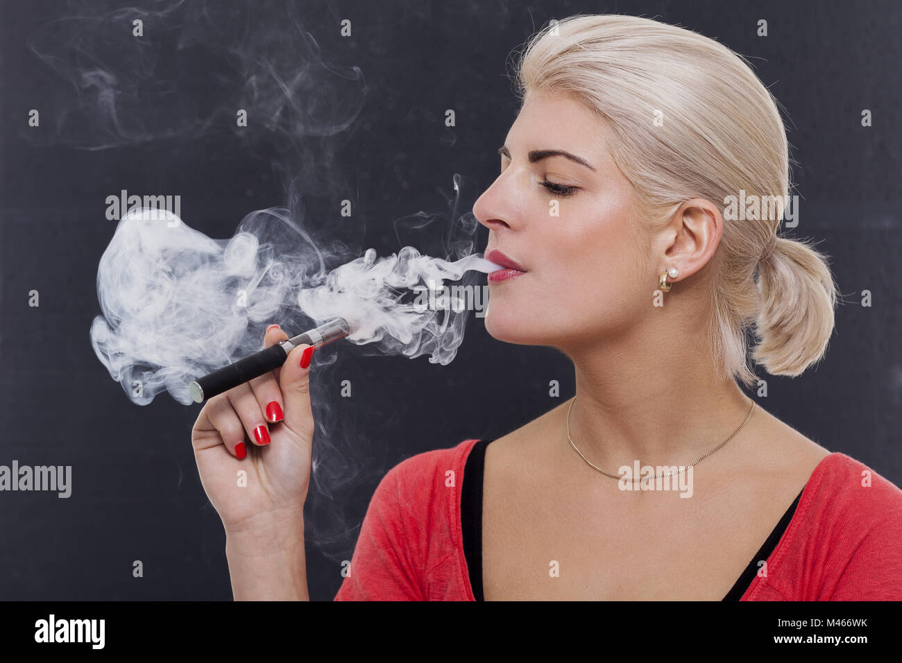 Stylish blond woman smoking e cigarette hi-res stock photography and ...