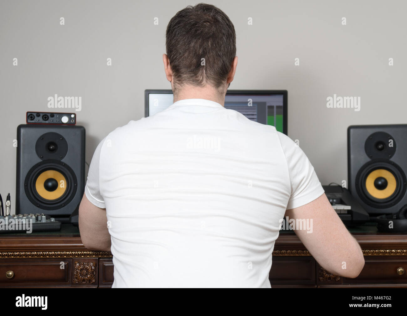 Male sound producer in recording studio. Back view. Space for your text ...