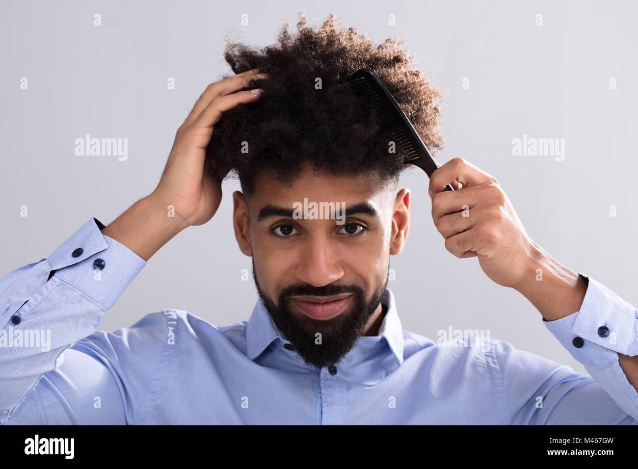 Portrait Of A Young Man Combing His Hair With Hair comb Stock Photo - Alamy