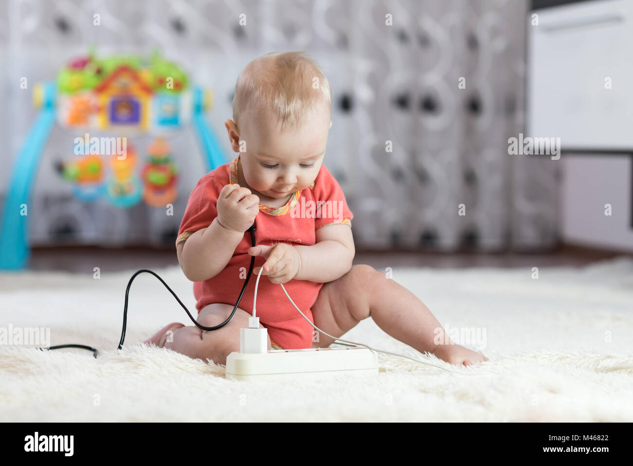 Baby playing with electrical outlet on floor at home Stock Photo - Alamy