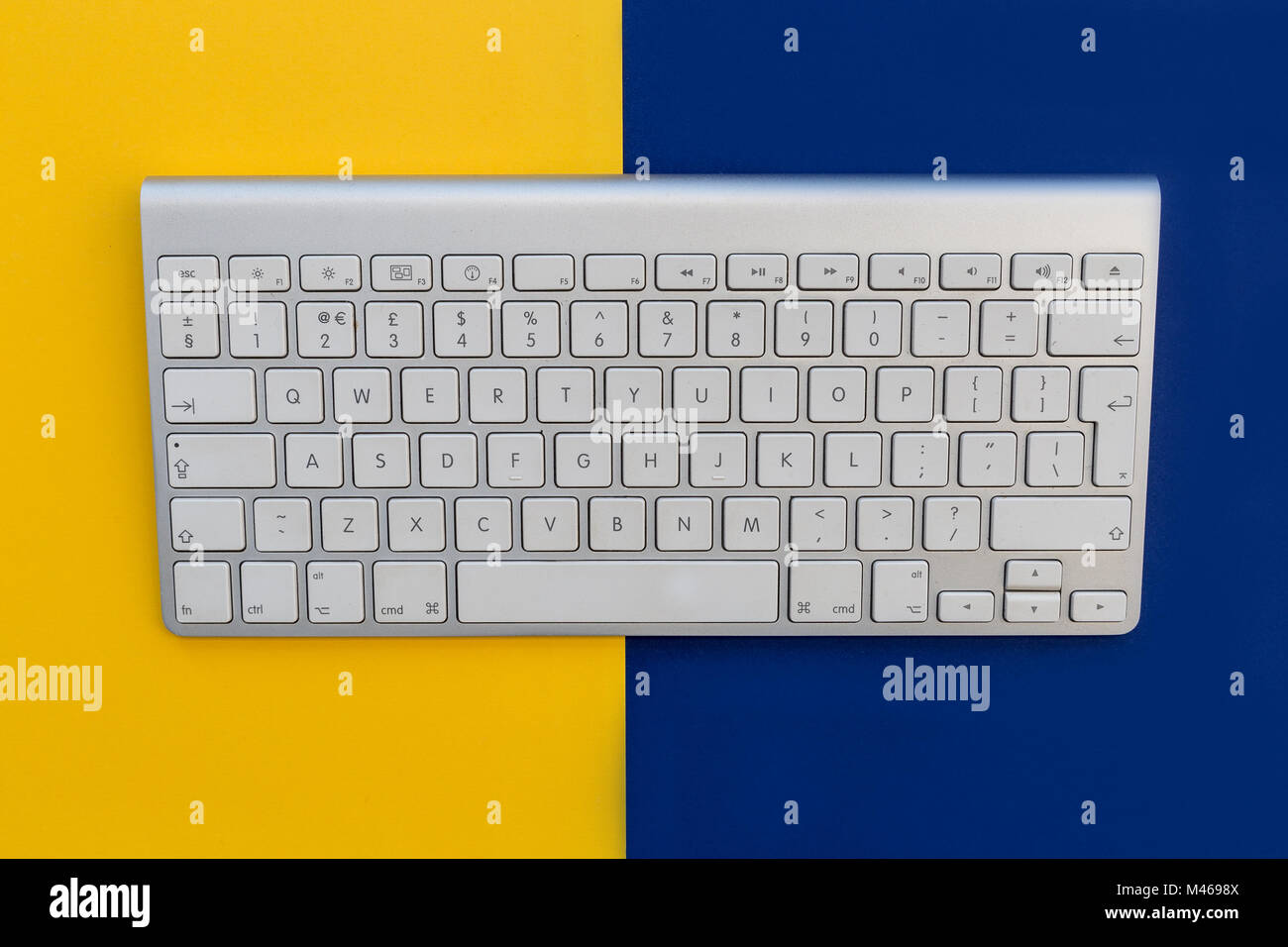 Wireless computer keyboard overhead on minimal bright yellow and blue ...