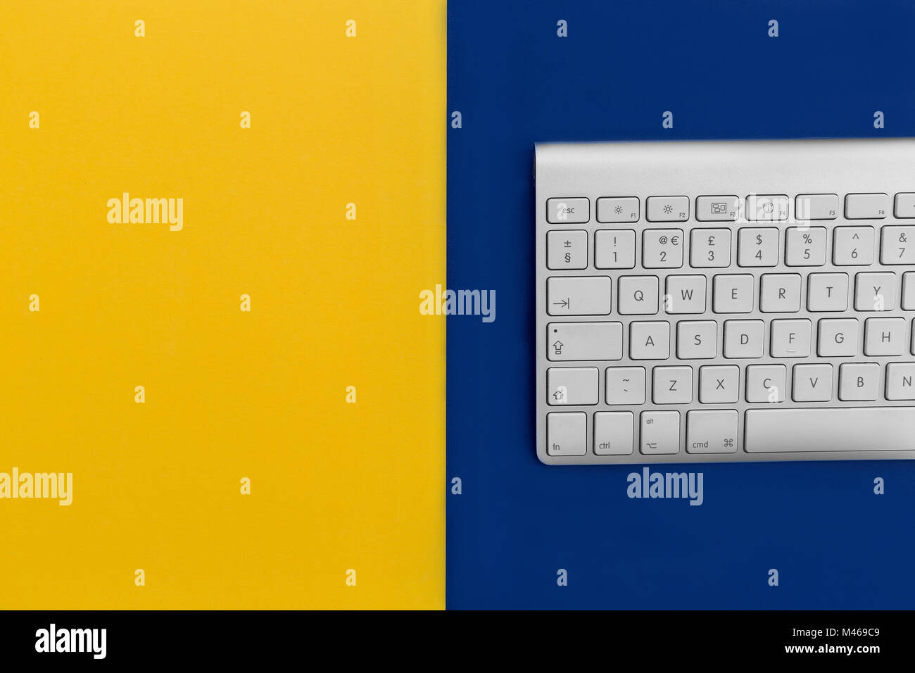 Wireless computer keyboard overhead on minimal bright yellow and blue ...