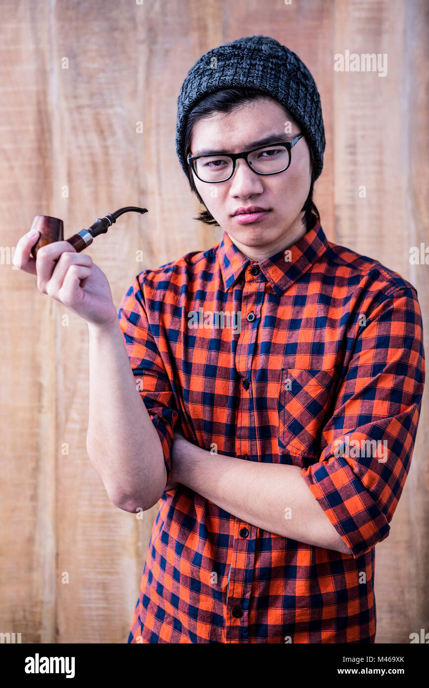 Serious hipster holding a pipe with crossed arms Stock Photo - Alamy