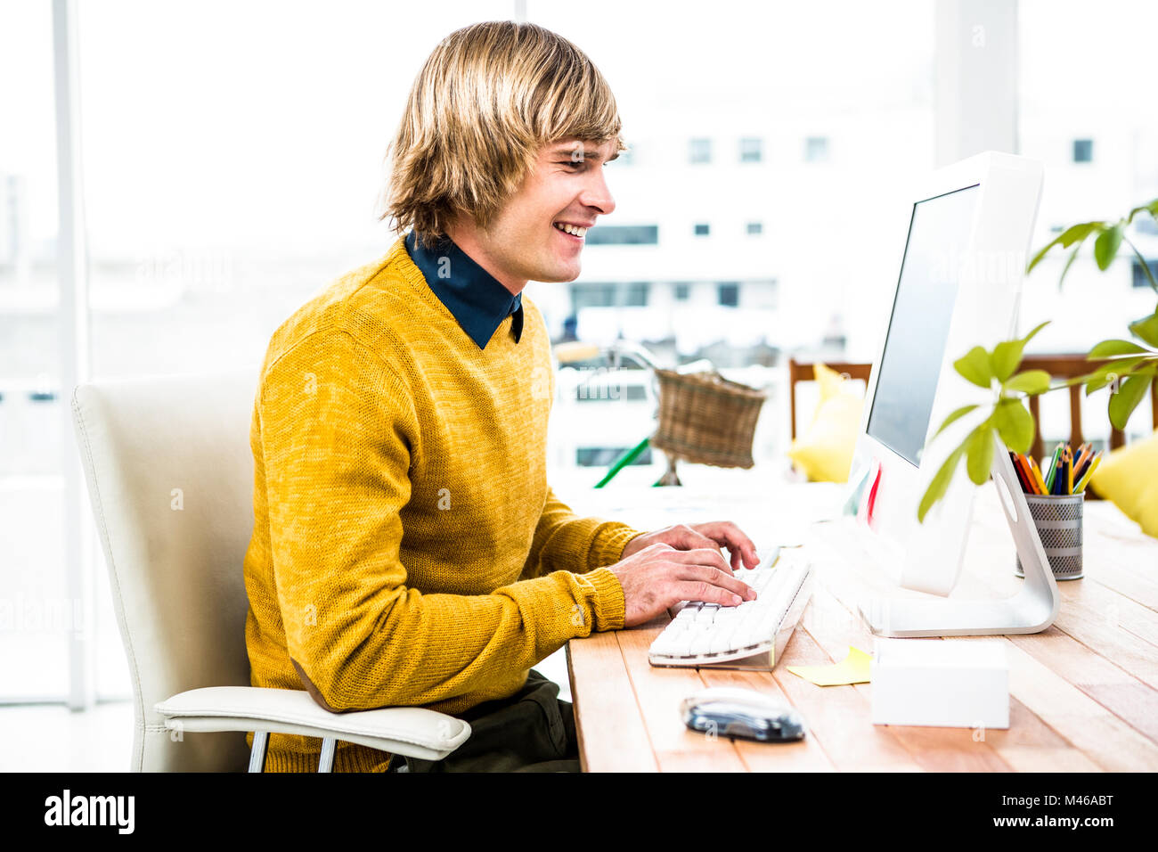 Smiling hipster businessman using his computer Stock Photo - Alamy