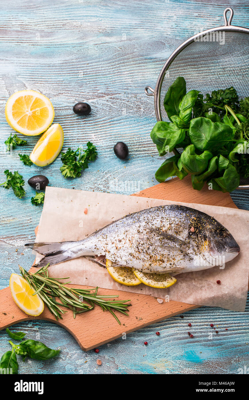Cooking Raw Dorado Fish with Spinach, rosemary, olives, Herbs, Spices ...