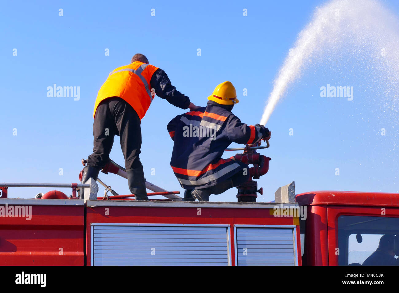 Firefighters in the fire fighting action Stock Photo - Alamy