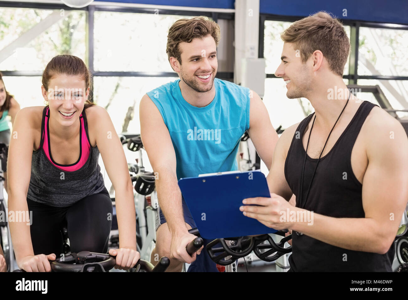 Fit group of people using exercise bike together Stock Photo - Alamy
