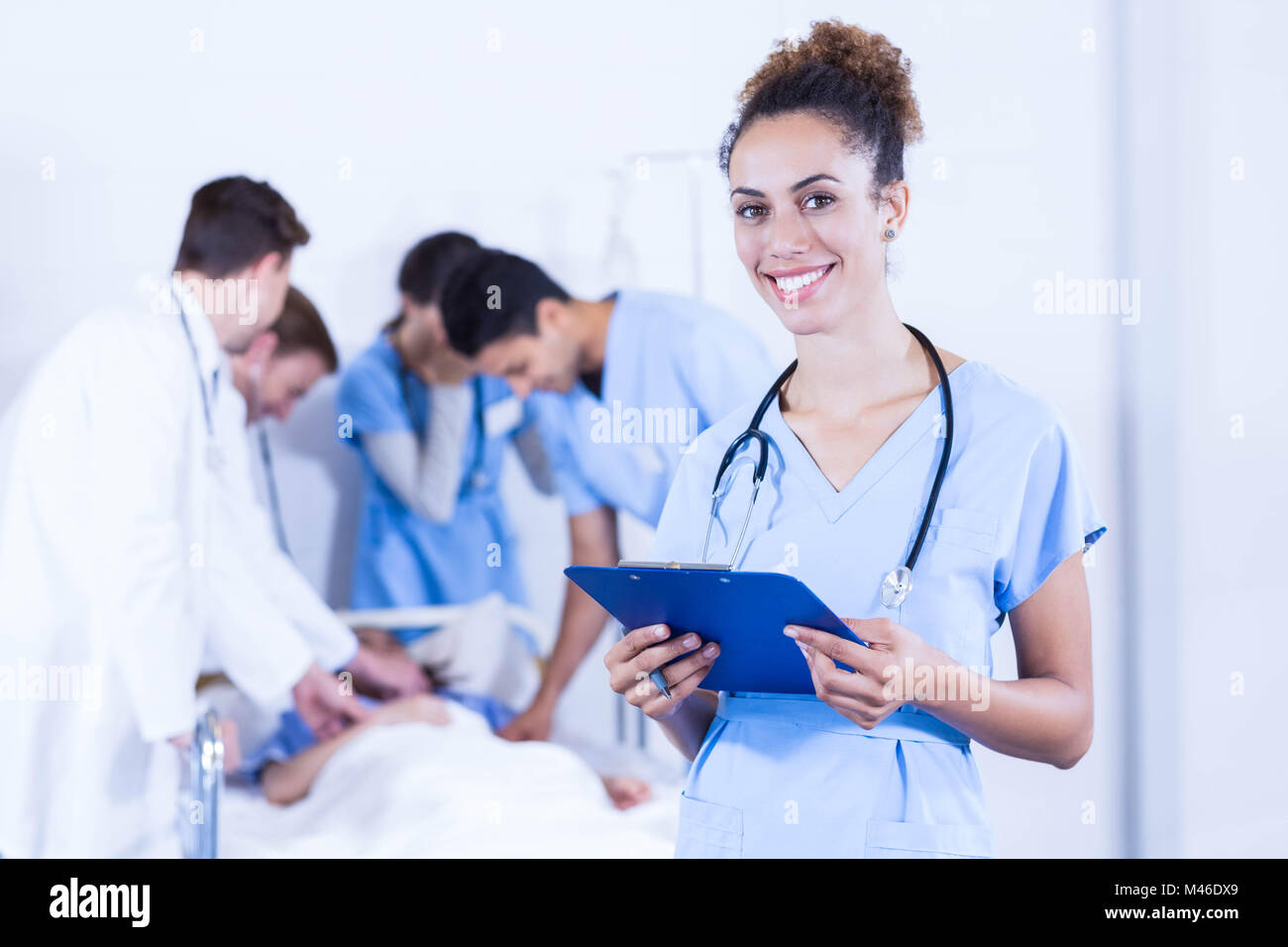 Female doctor holding clipboard and smiling at camera Stock Photo - Alamy