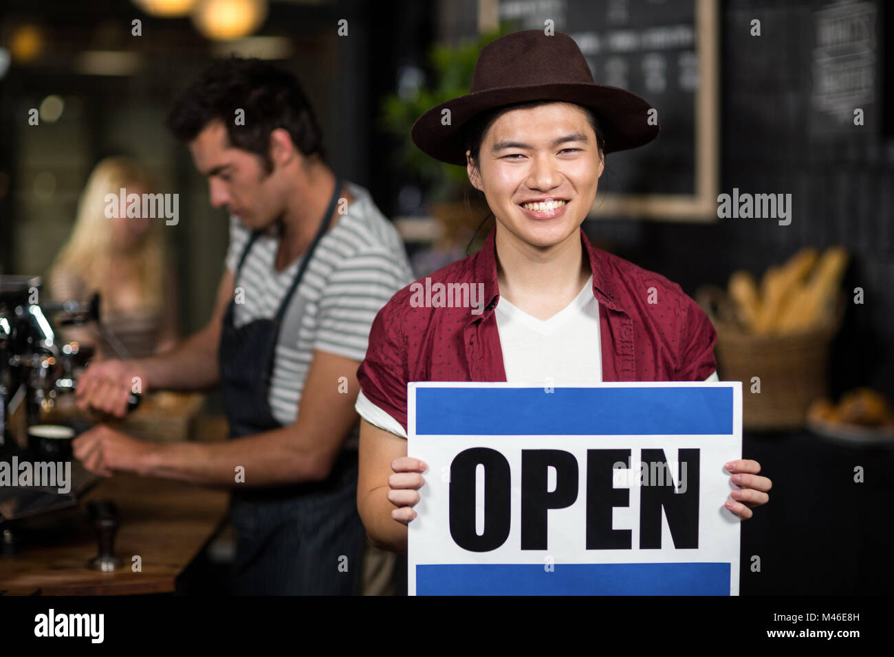 Portrait of a asian waiter showing open sign Stock Photo - Alamy