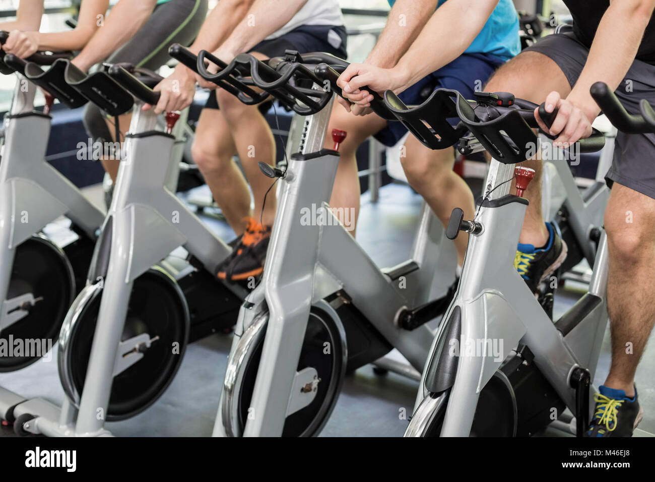 Fit group of people using exercise bike together Stock Photo - Alamy