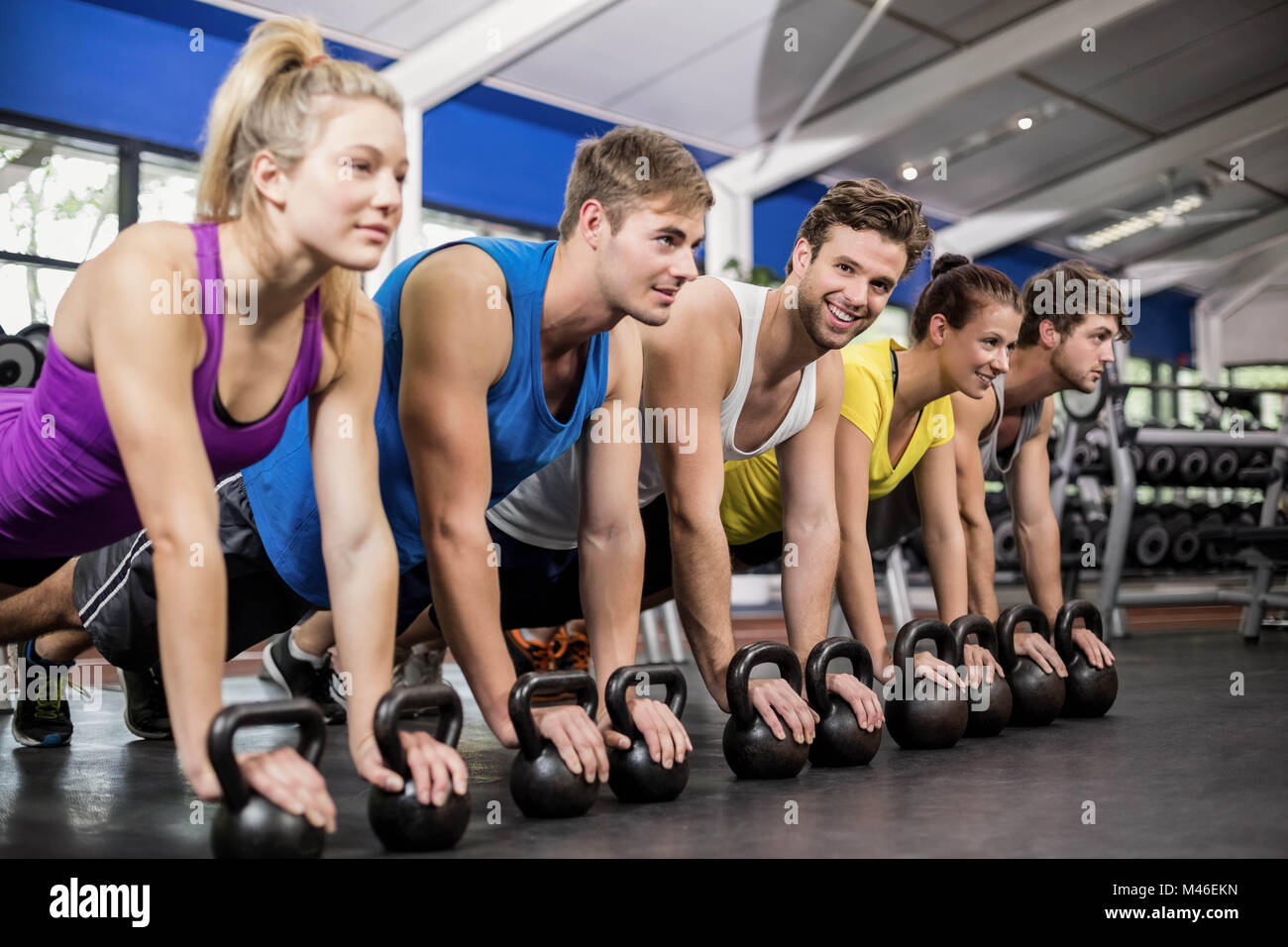 Fitness class in plank position with dumbbells Stock Photo - Alamy