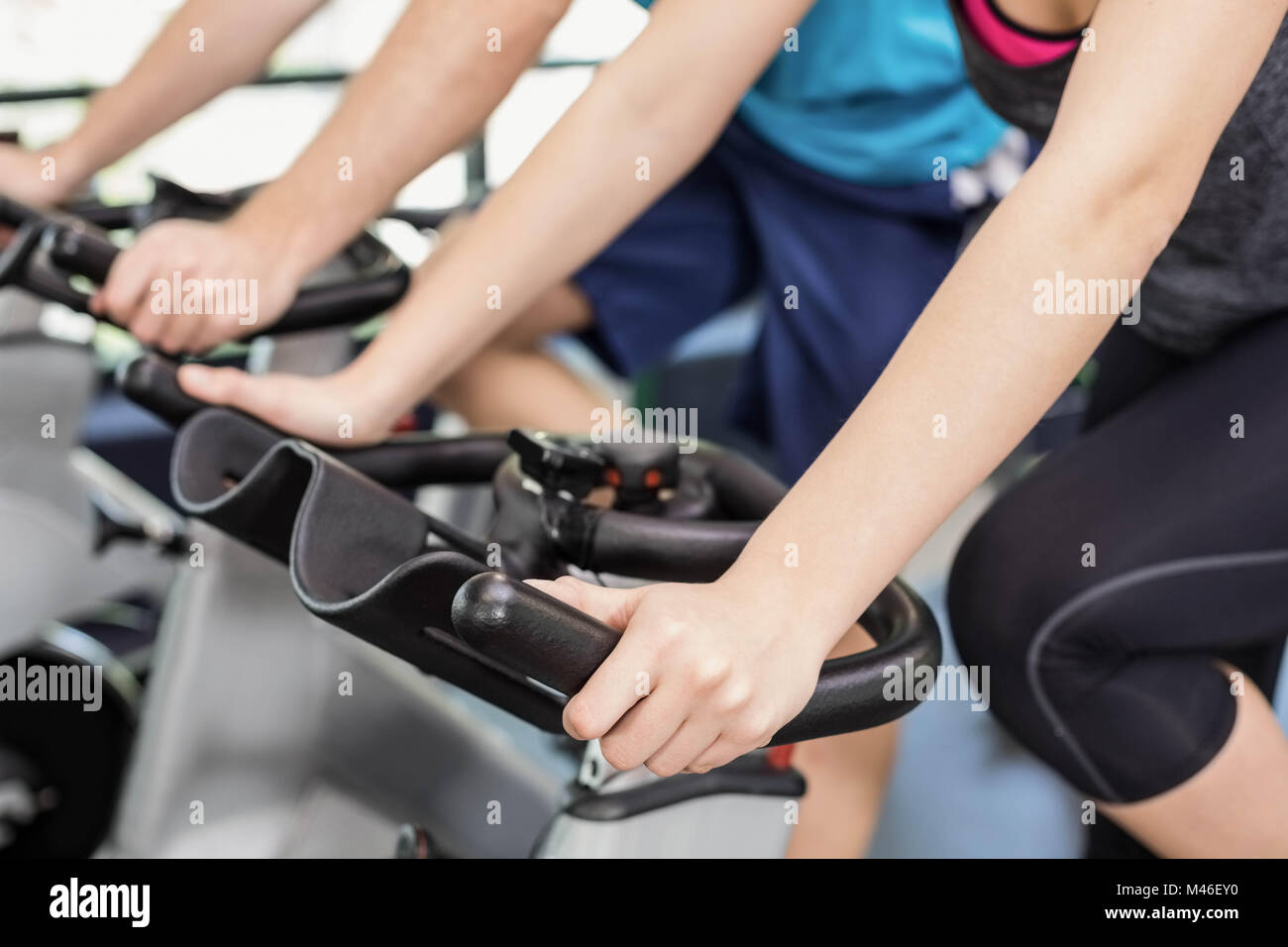 Fit group of people using exercise bike together Stock Photo - Alamy