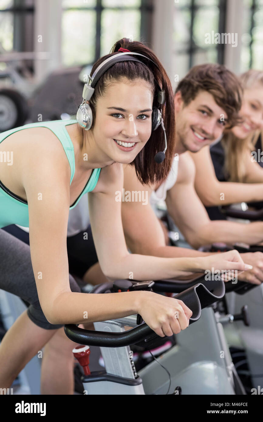 Fit group of people using exercise bike together Stock Photo - Alamy