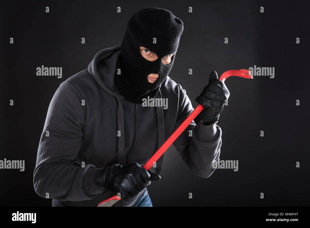 Portrait Of A Burglar Wearing Balaclava Holding Crowbar On Black ...