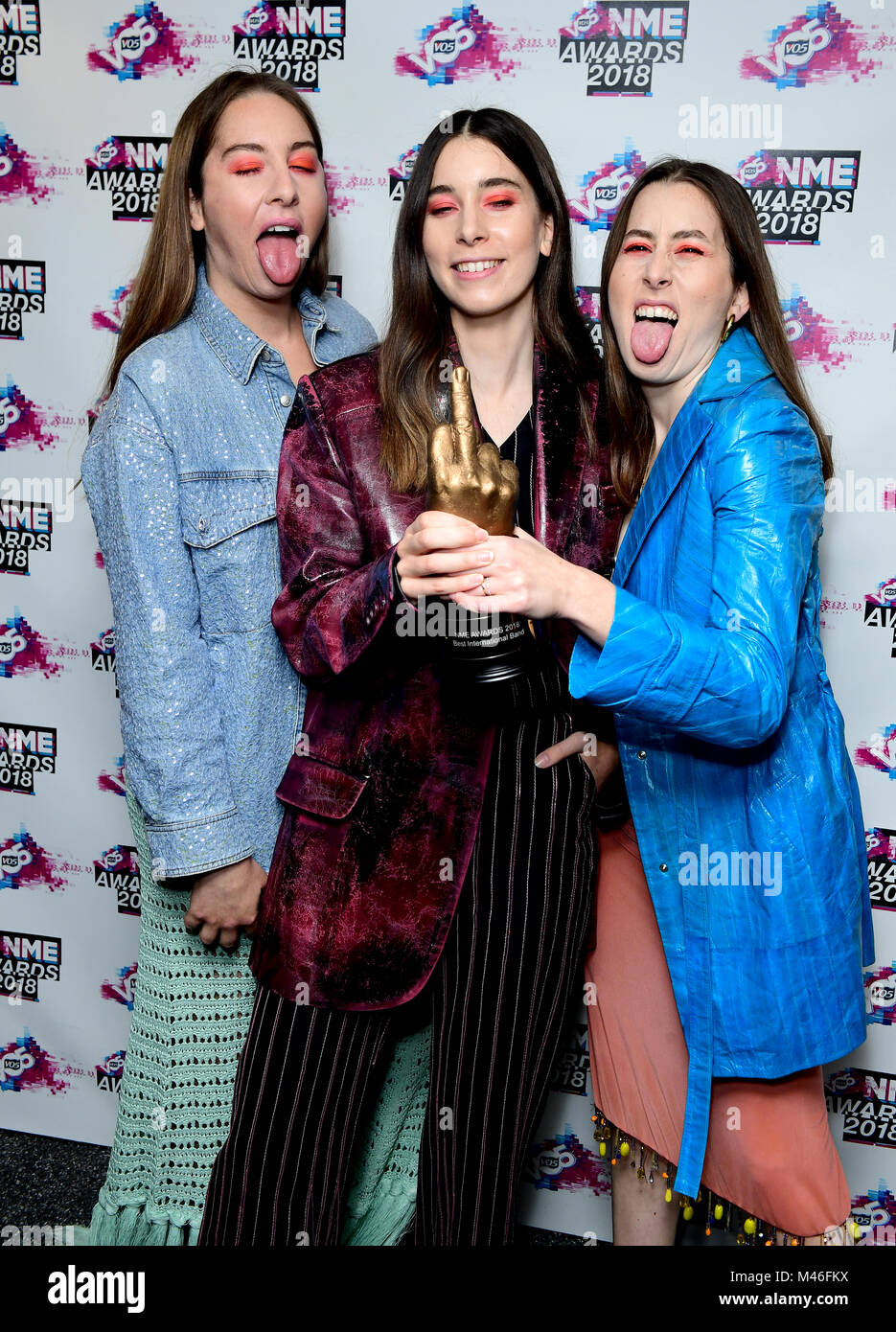 HAIM holding the award for Best International Band in the awards room ...