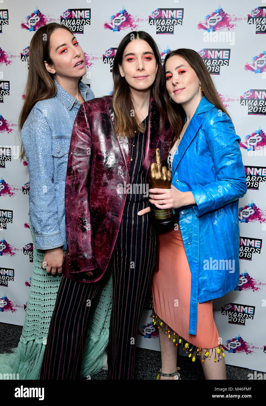 HAIM holding the award for Best International Band in the awards room ...