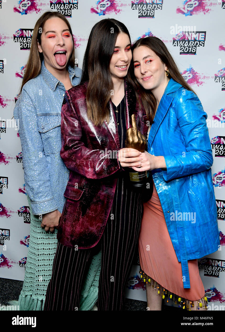 HAIM holding the award for Best International Band in the awards room ...