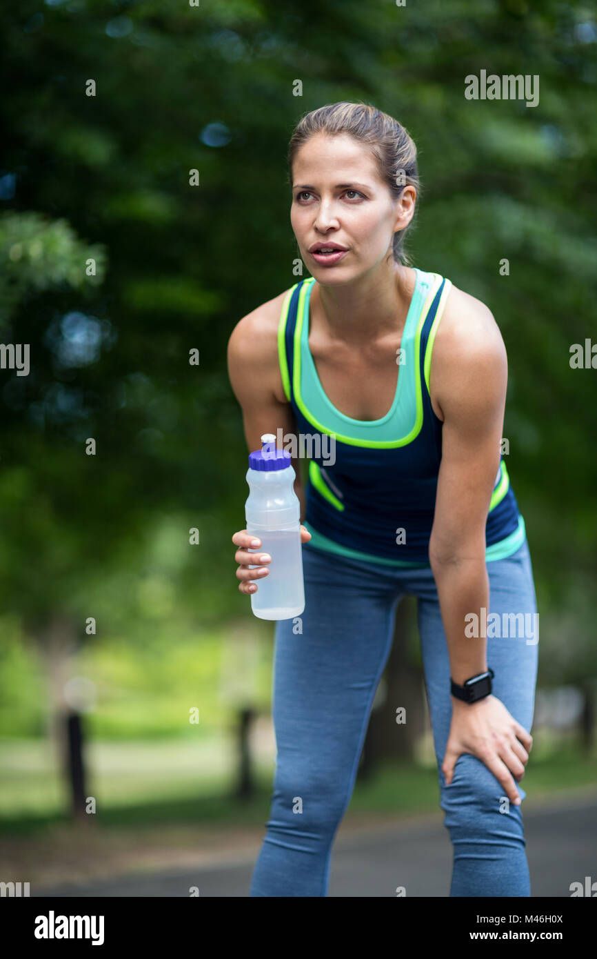 Marathon female athlete running drinking water Stock Photo - Alamy