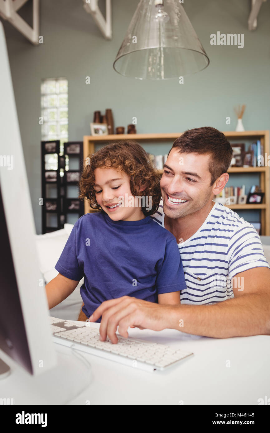 Cheerful father and son using computer at home Stock Photo - Alamy