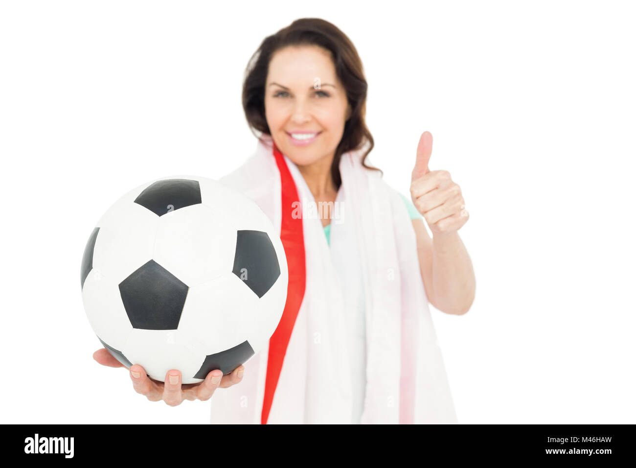 Pretty brunette with thumbs up holding soccer ball Stock Photo - Alamy