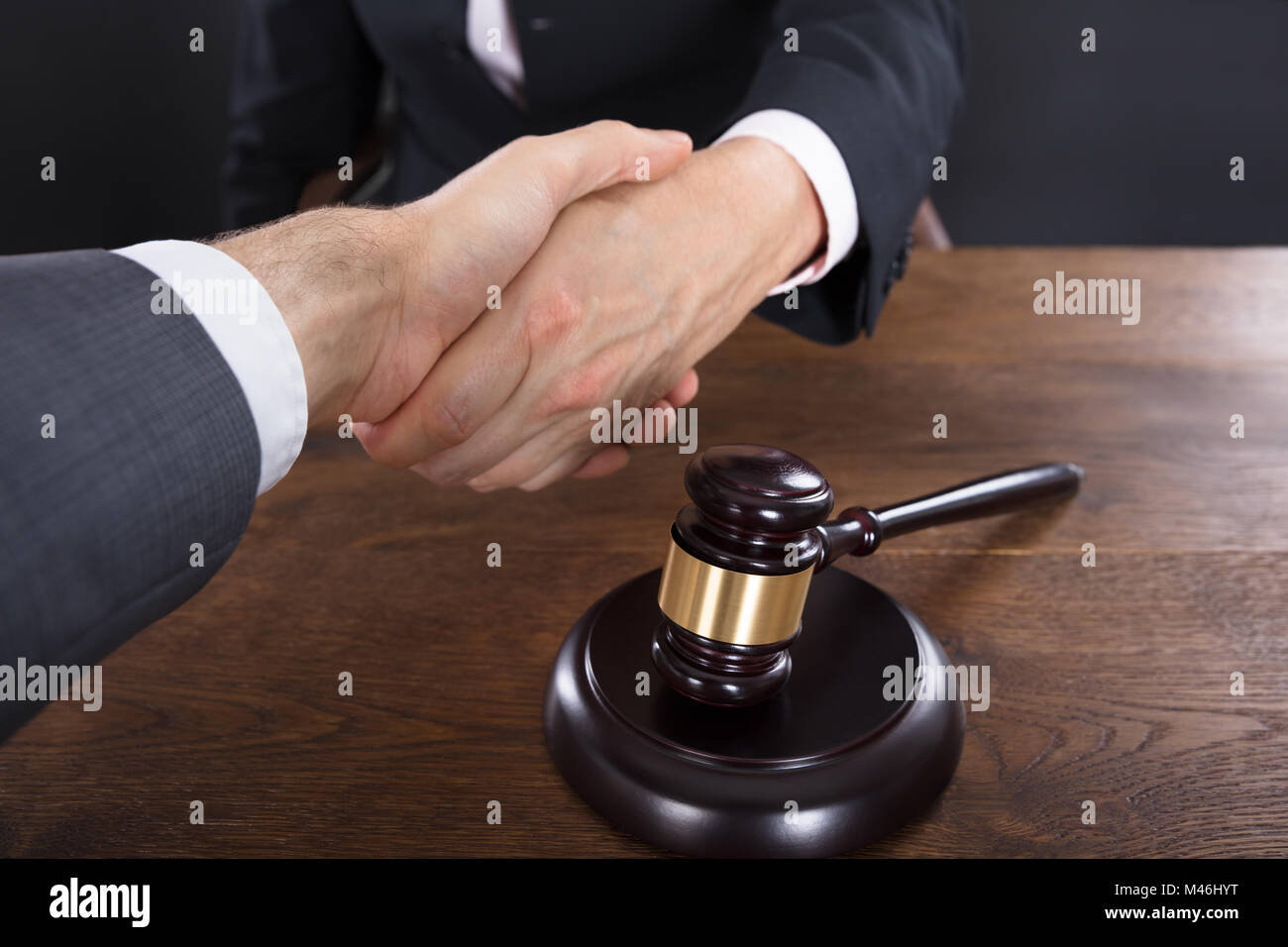 Close-up Of A Client And Judge Shaking Hands With Each Other Near Gavel ...