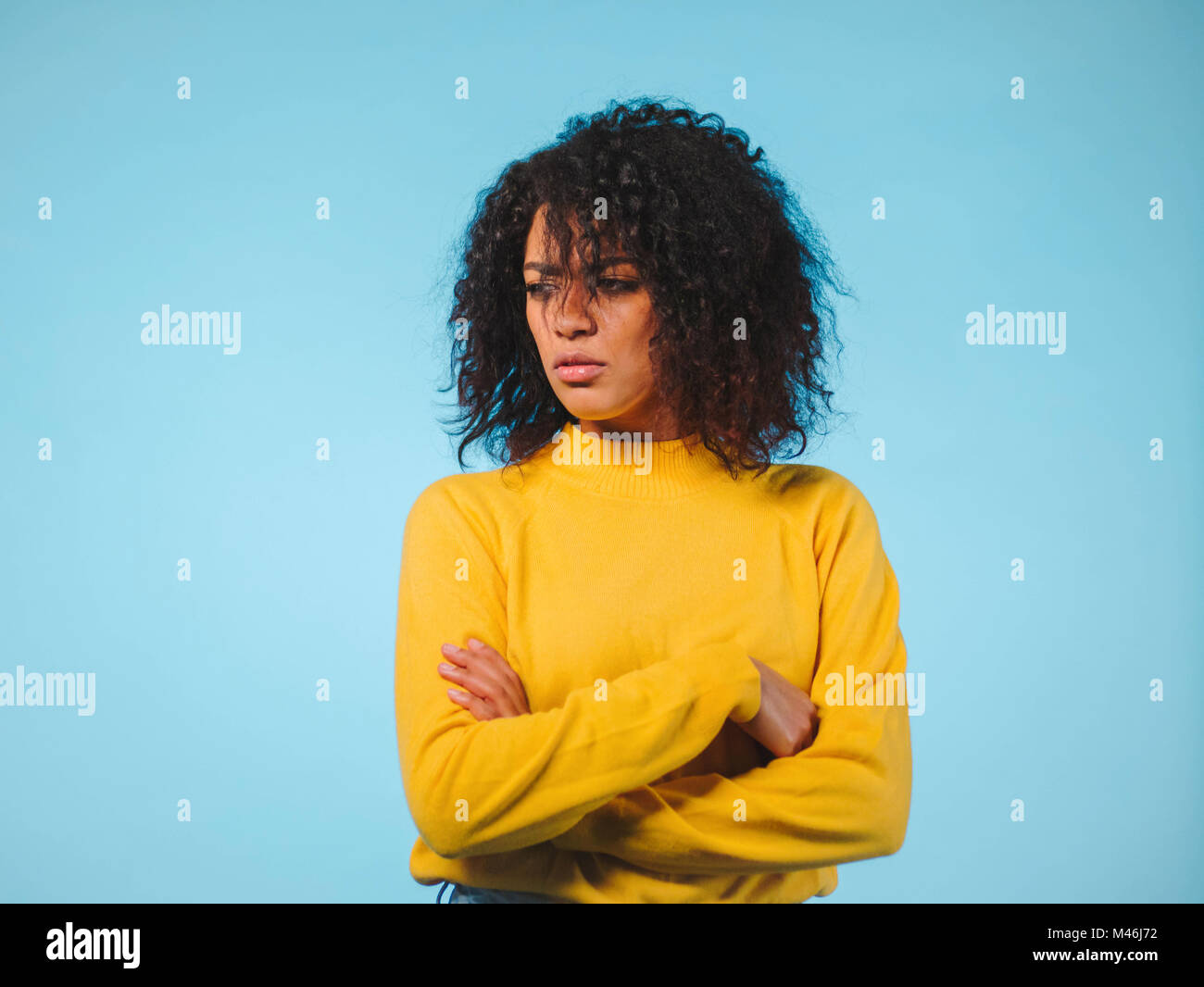 Angry annoyed young housewife keeping arms crossed and staring at ...