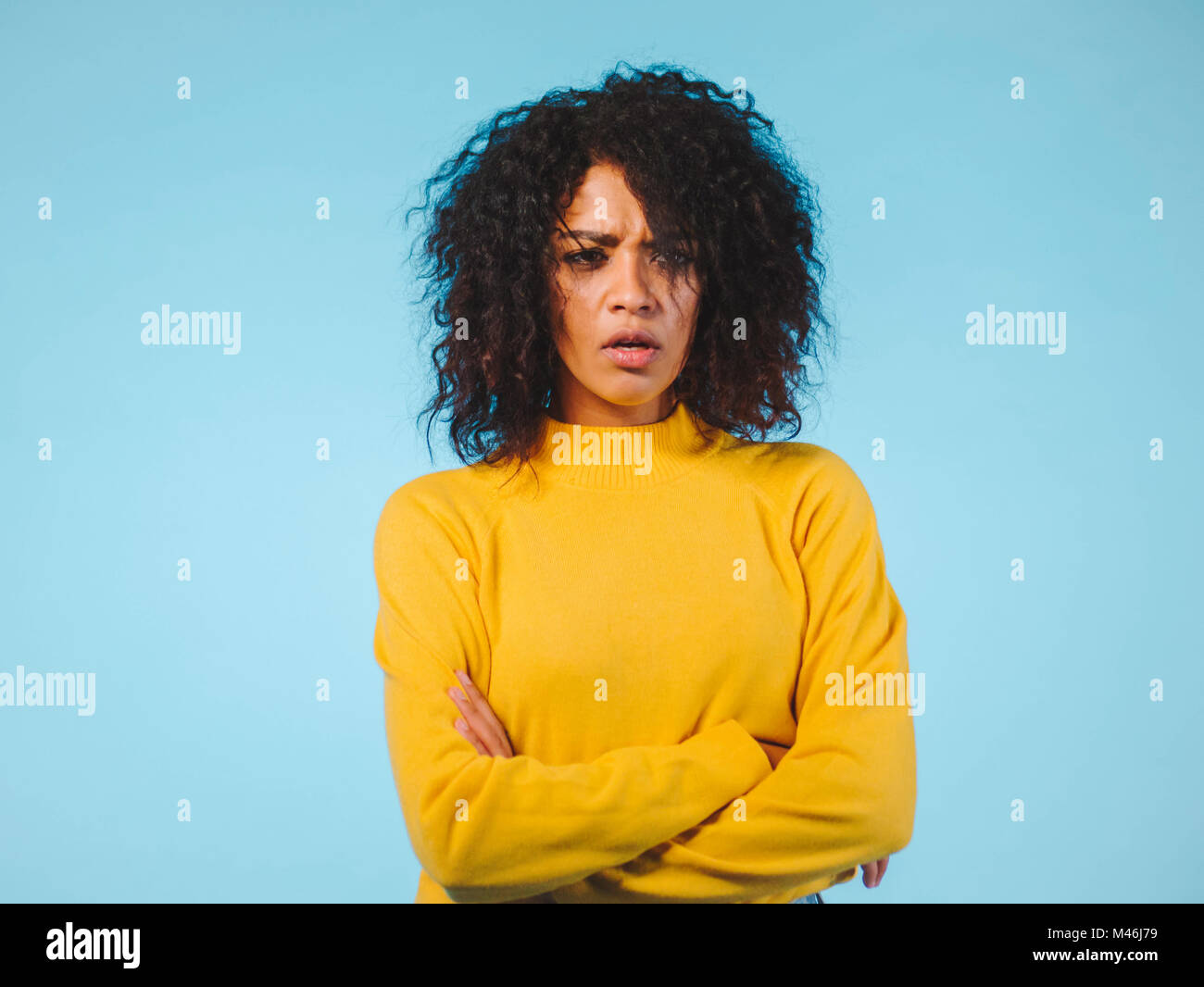 Angry annoyed young housewife keeping arms crossed and staring at ...