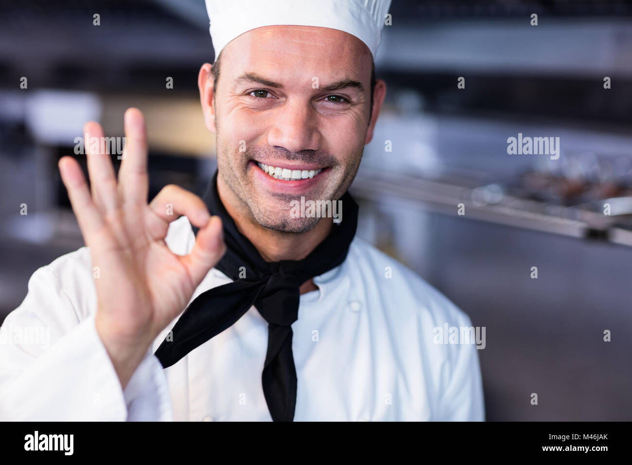 Happy chef making ok sign in commercial kitchen Stock Photo - Alamy