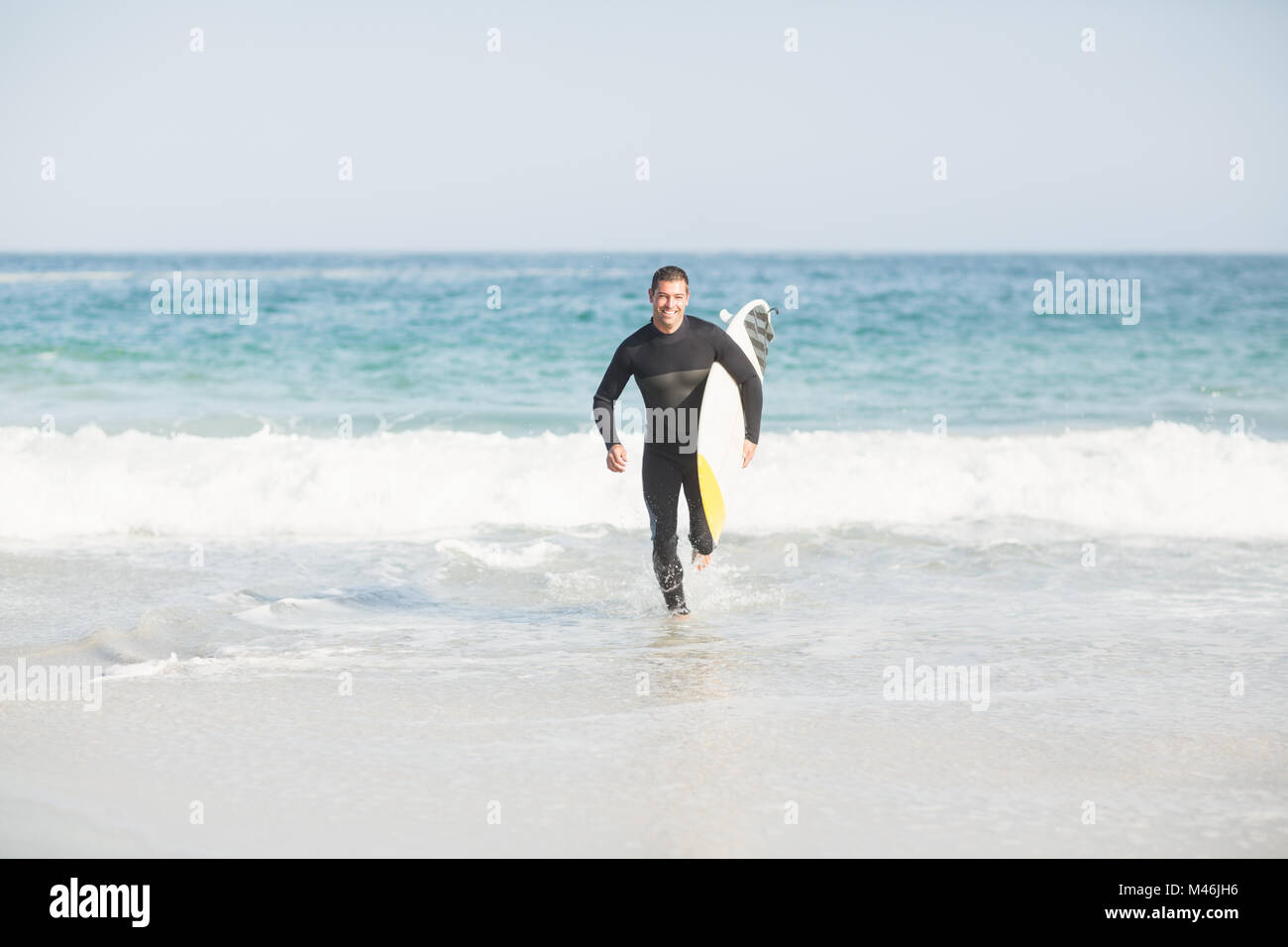 Surfer running on the beach with a surfboard Stock Photo - Alamy