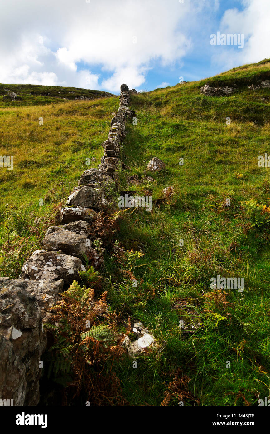 Stone wall with green pasture on the over looking the Sound of Mull on ...