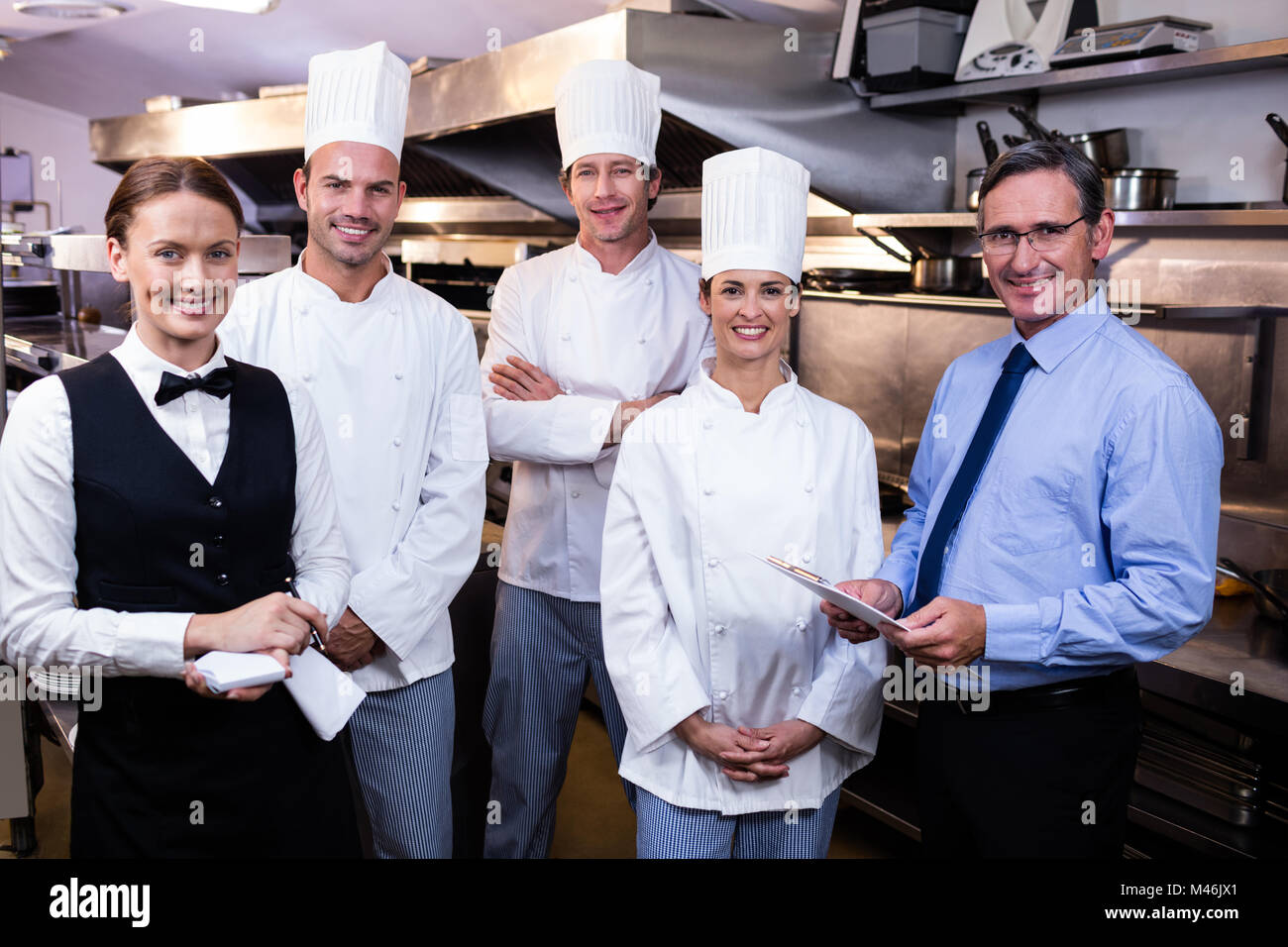 Happy restaurant team standing together in commercial kitchen Stock ...