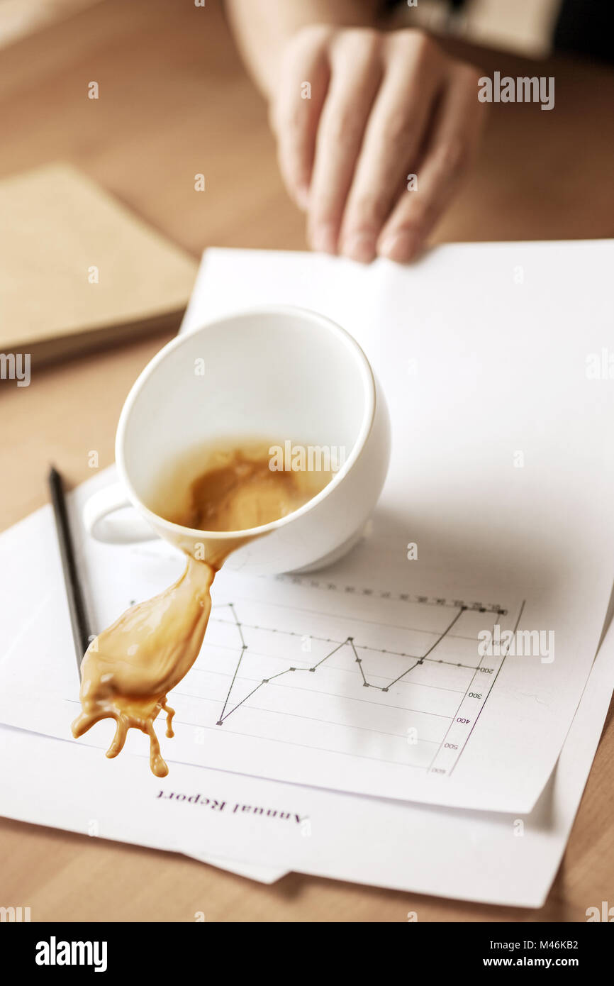 Coffee in white cup spilling on the table in the morning working day at ...