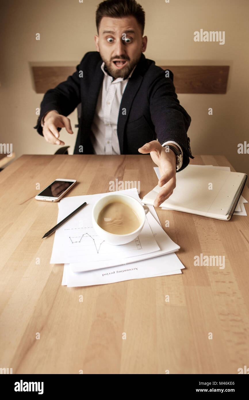 Coffee in white cup spilling on the table in the morning working day at ...
