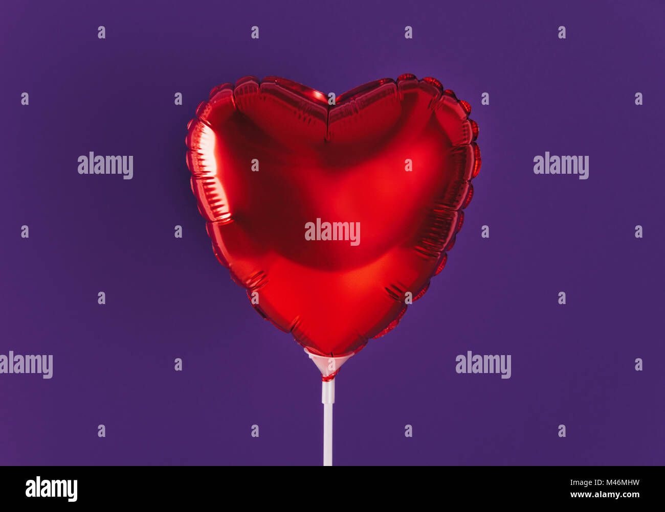 Red heart balloon on ultra violet background Stock Photo - Alamy