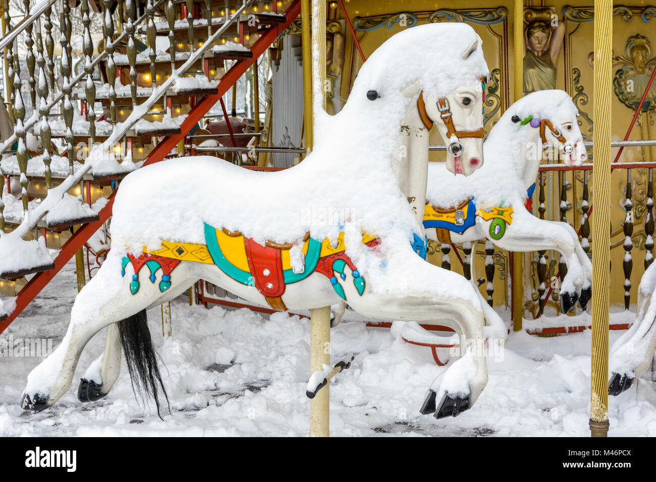 Vintage style wooden carousel horses covered in snow Stock Photo - Alamy