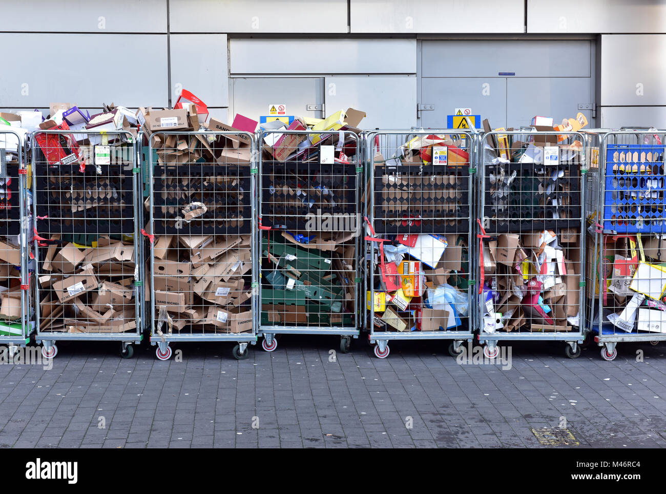 a row or line of cages of cardboard and paper for recycling ready for ...