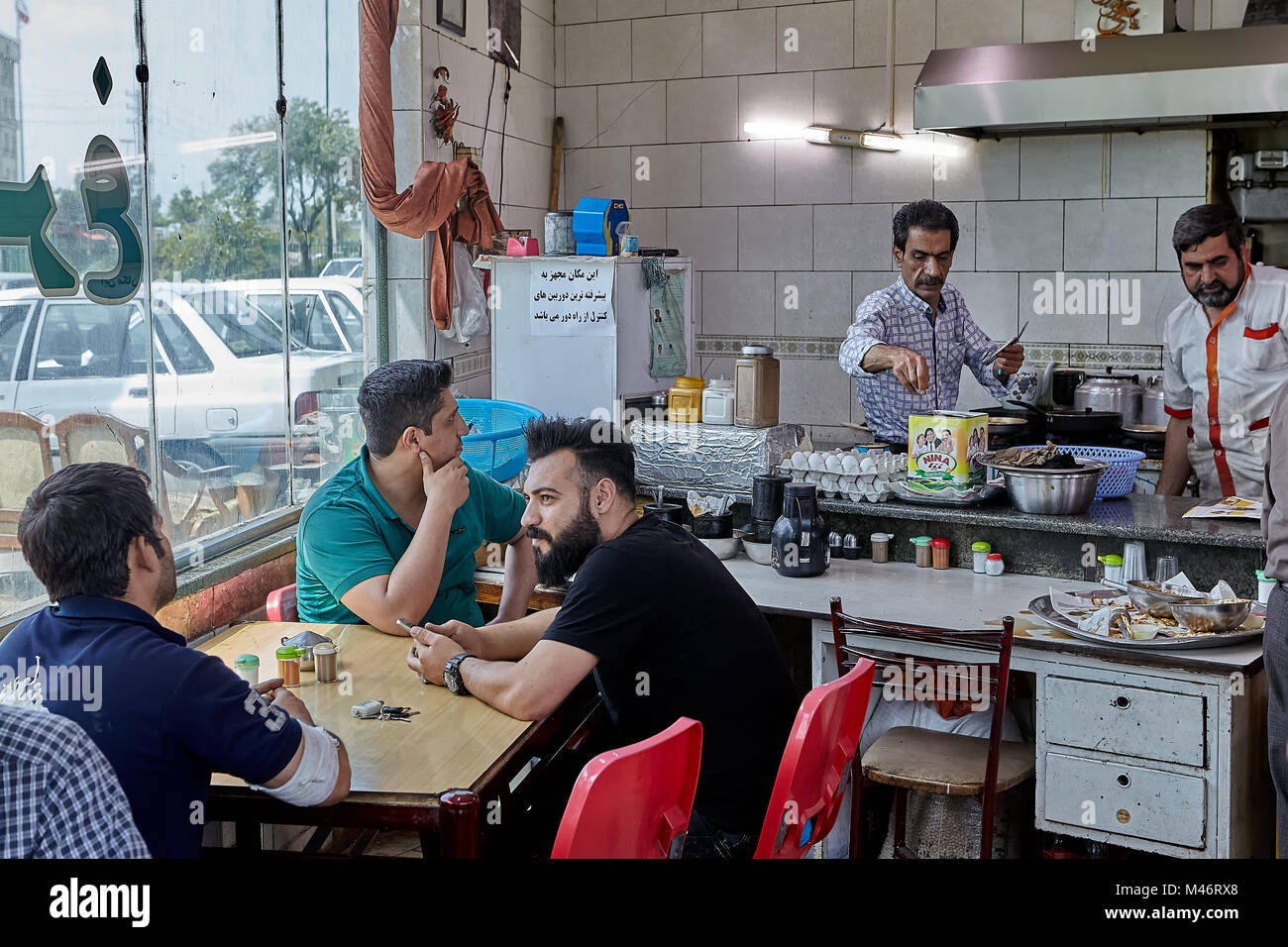 Tehran, Iran - April 28, 2017: Iranian men sit at a table in a small ...