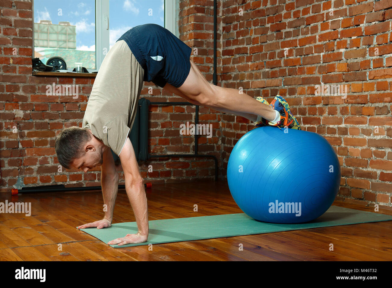 Athletic man doing balancing exercises with the gym ball Stock Photo ...