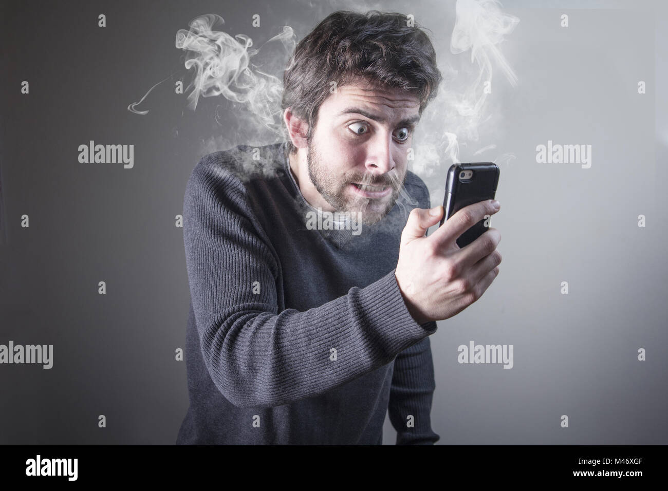 Man furious with his phone smoking with rage Stock Photo - Alamy