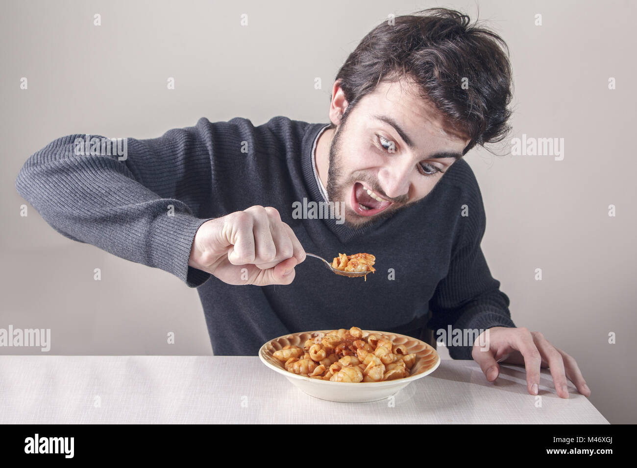 Hungry man eating food Stock Photo - Alamy