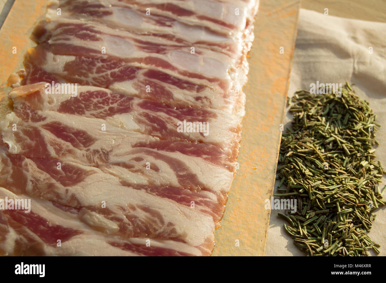 Delicious raw sliced bacon with dried rosemary Stock Photo - Alamy