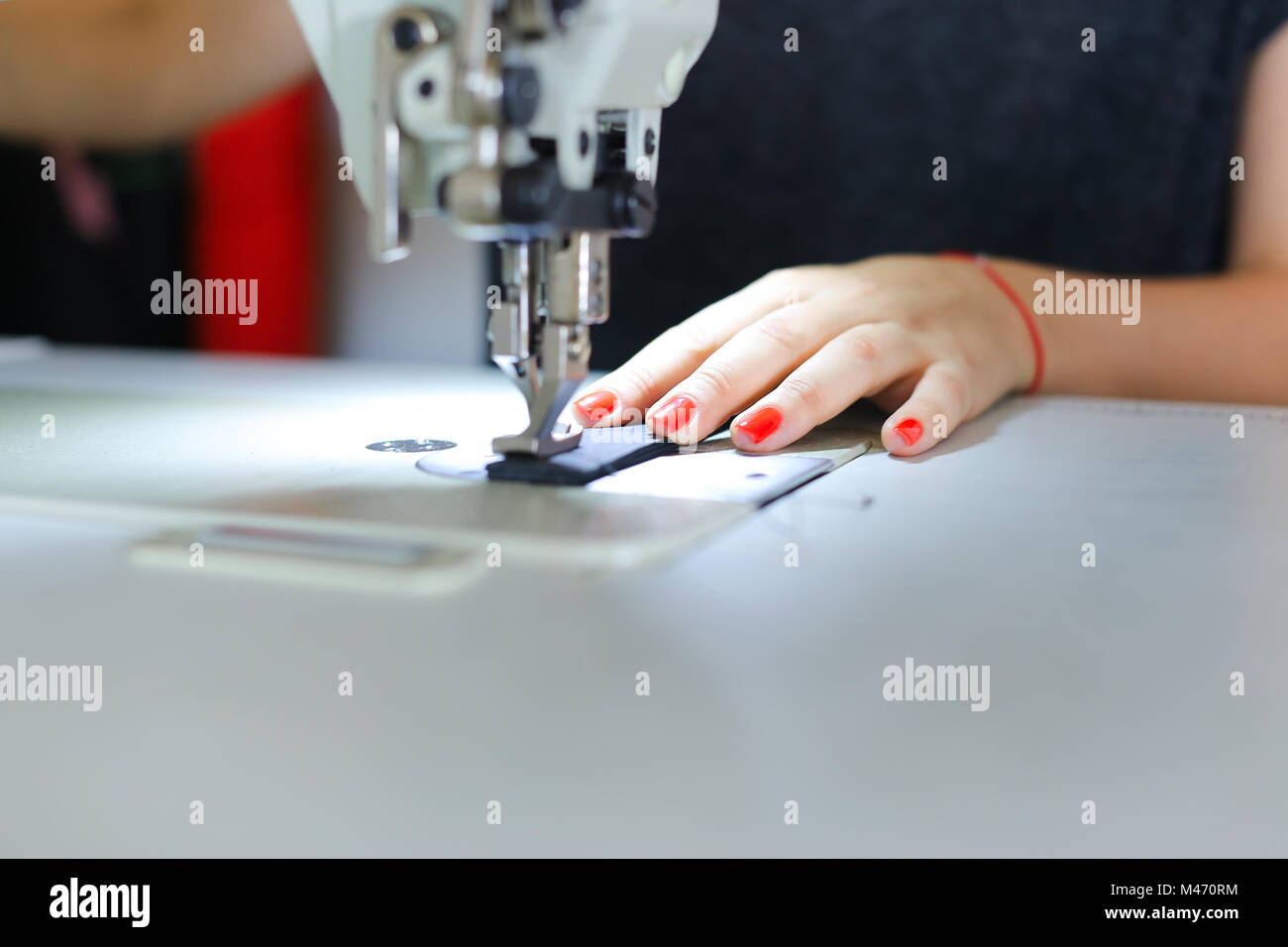 Seamstress sewing belt using sewing machine Stock Photo - Alamy