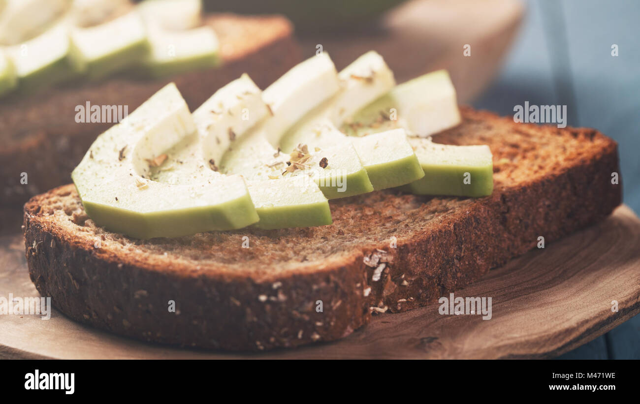 toasted rye bread with sliced avocado and herbs Stock Photo - Alamy