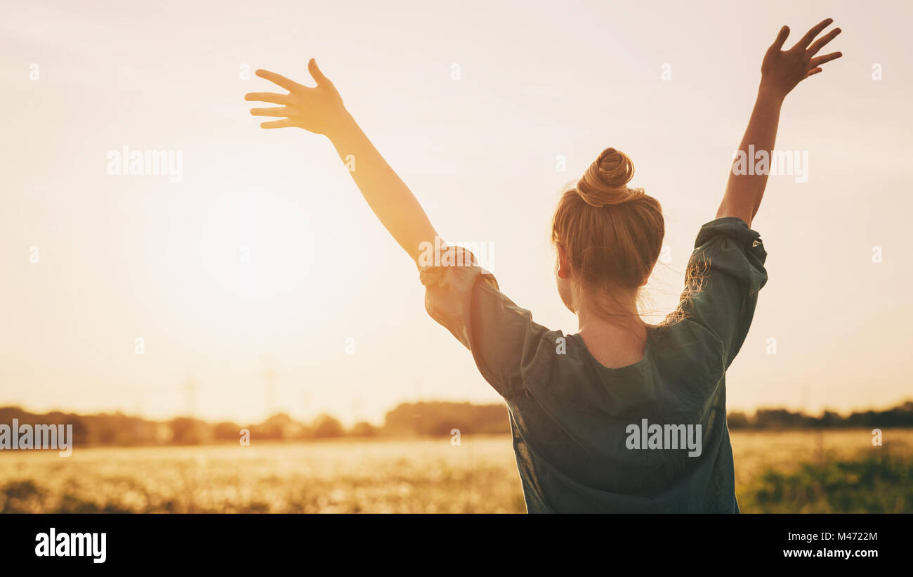 female teen girl stand feel freedom with arms stretched to the sky ...