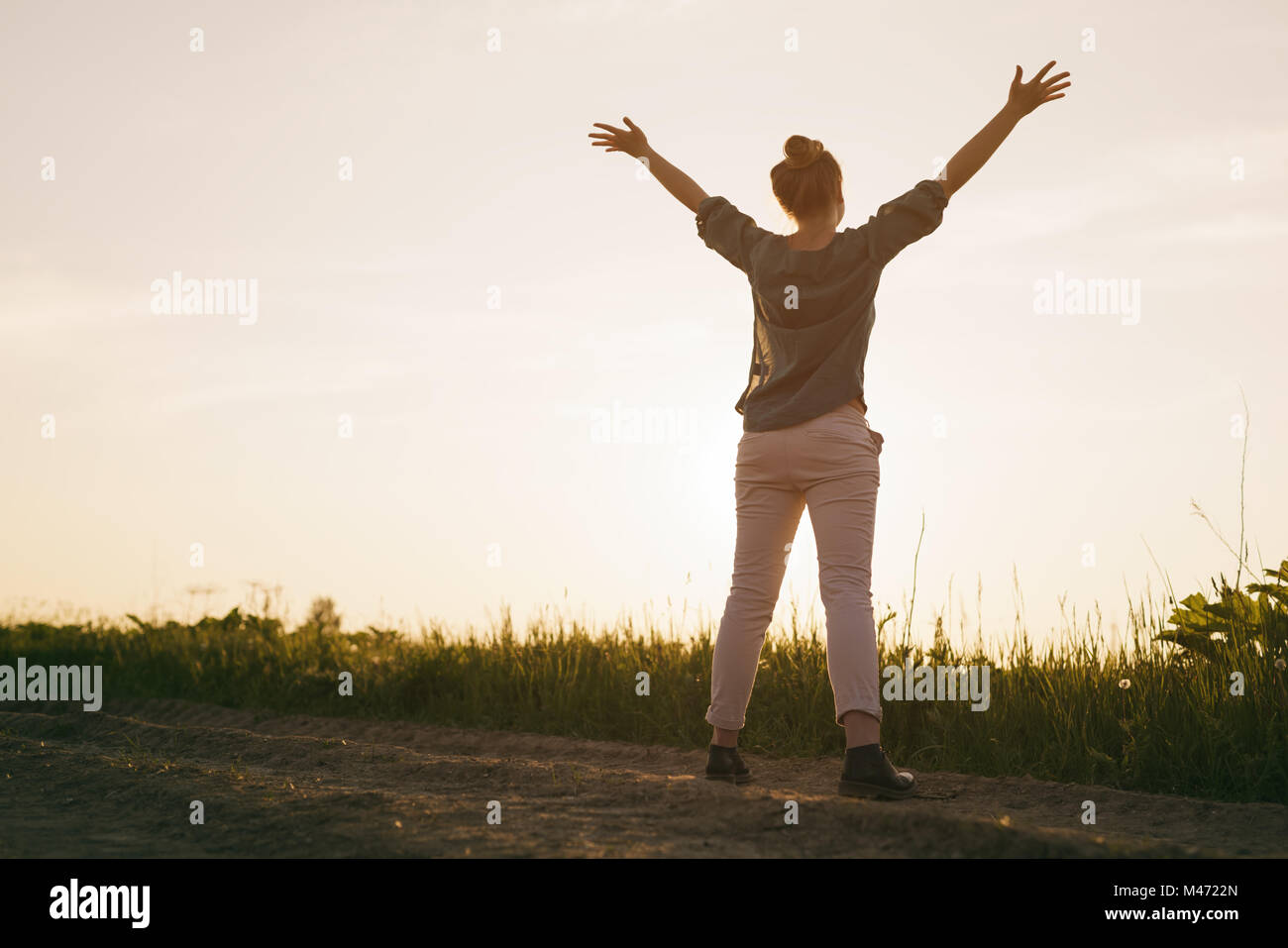 female teen girl stand feel freedom with arms stretched to the sky copy ...
