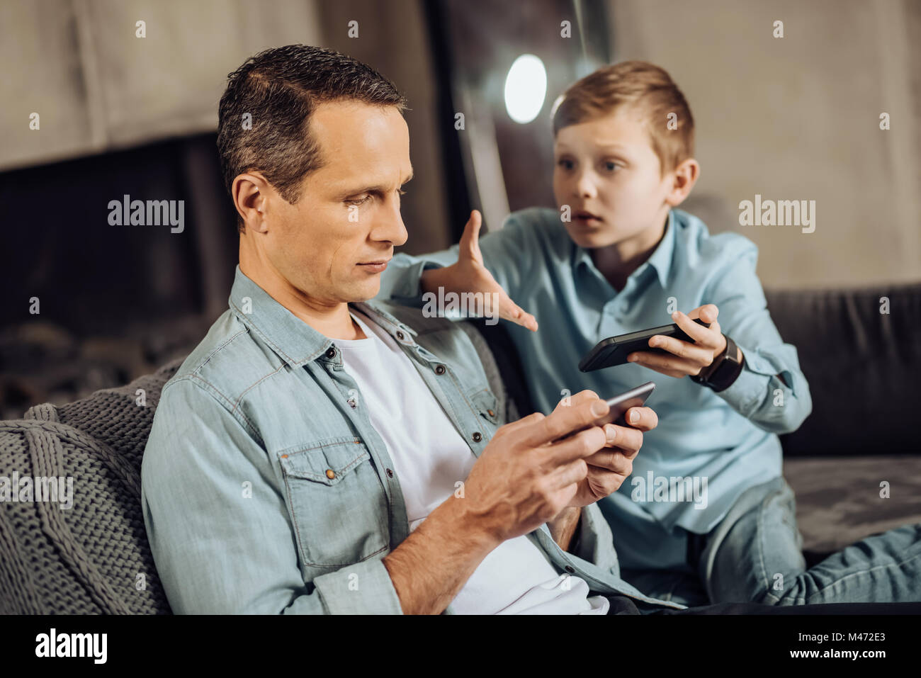 Little boy trying to attract his fathers attention Stock Photo - Alamy