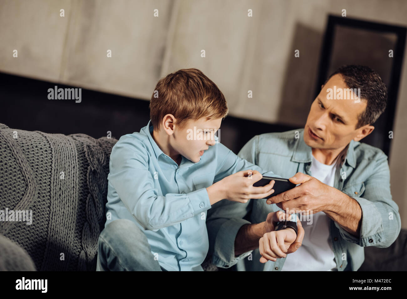 Irritated father and son fighting over a phone Stock Photo - Alamy
