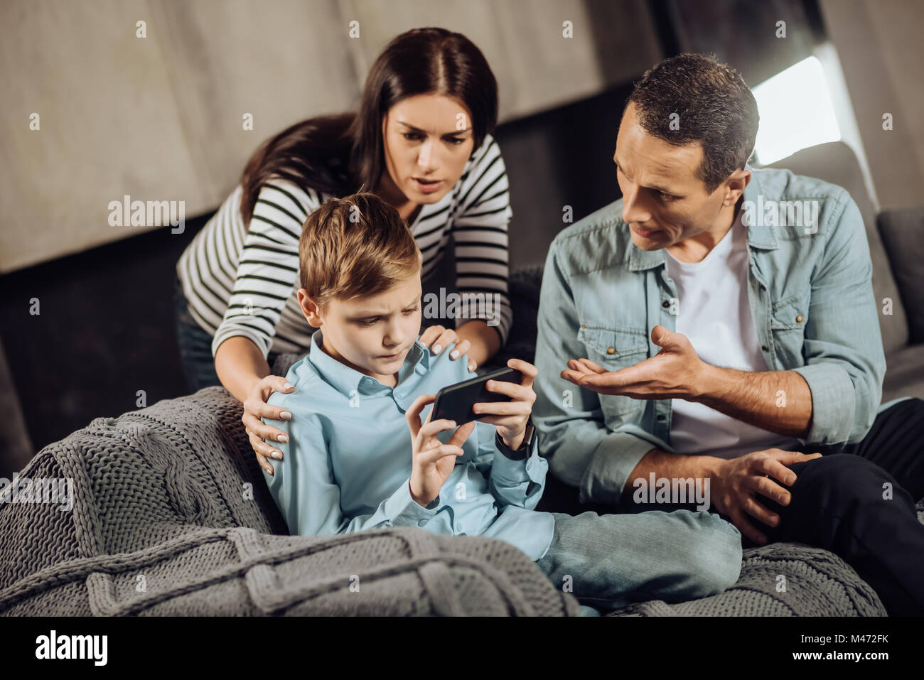 Loving parents convincing son to put down the phone Stock Photo - Alamy