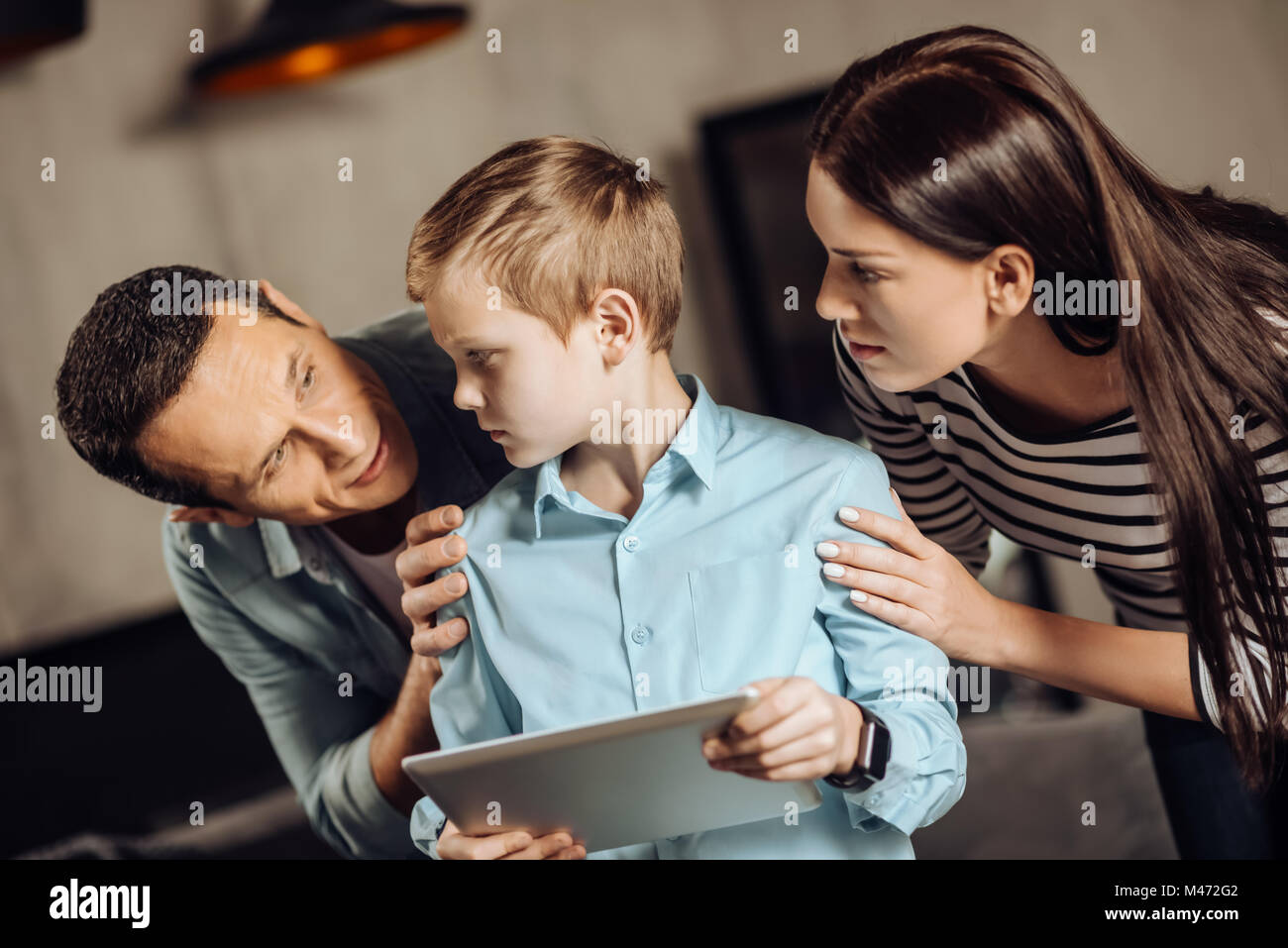 Young parents gently persuading son to put down tablet Stock Photo - Alamy